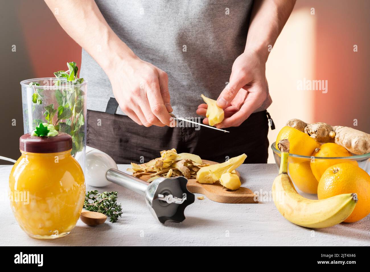 A man peels a ginger. Knife and ginger slices. Prepare a dish with ...
