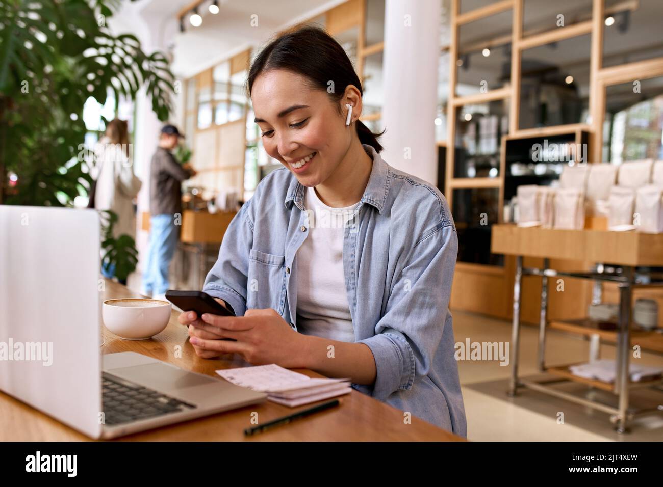 Young smiling Asian woman student using smartphone for elearning Stock ...