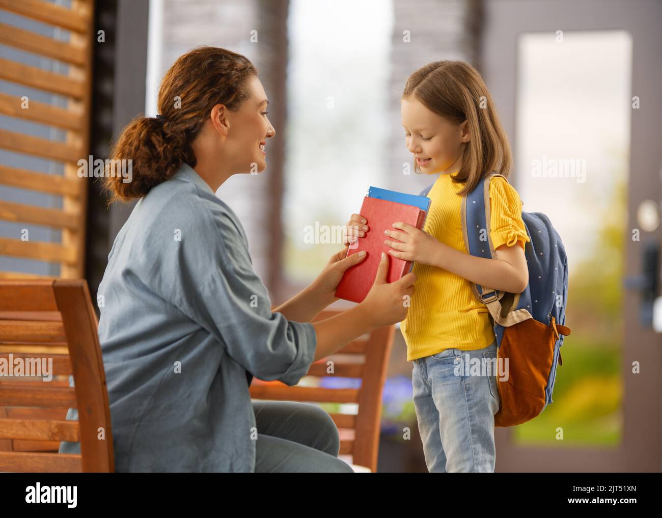 Parent and pupil of primary school going hand in hand. Woman and girl ...