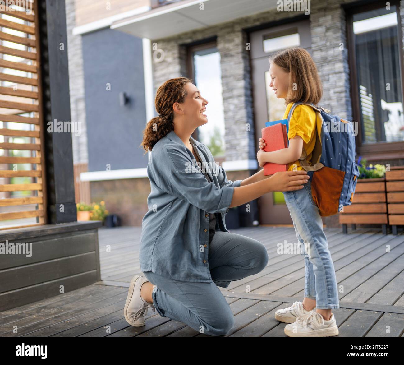 Parent and pupil of primary school going hand in hand. Woman and girl ...