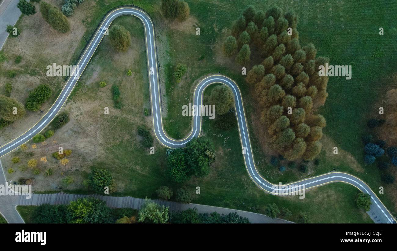 Winding bike path in the city park. City park at dawn. Aerial ...