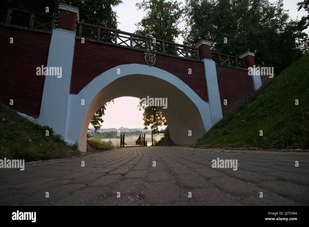 Pedestrian bridge with an arch in the city park. The camera Installed ...