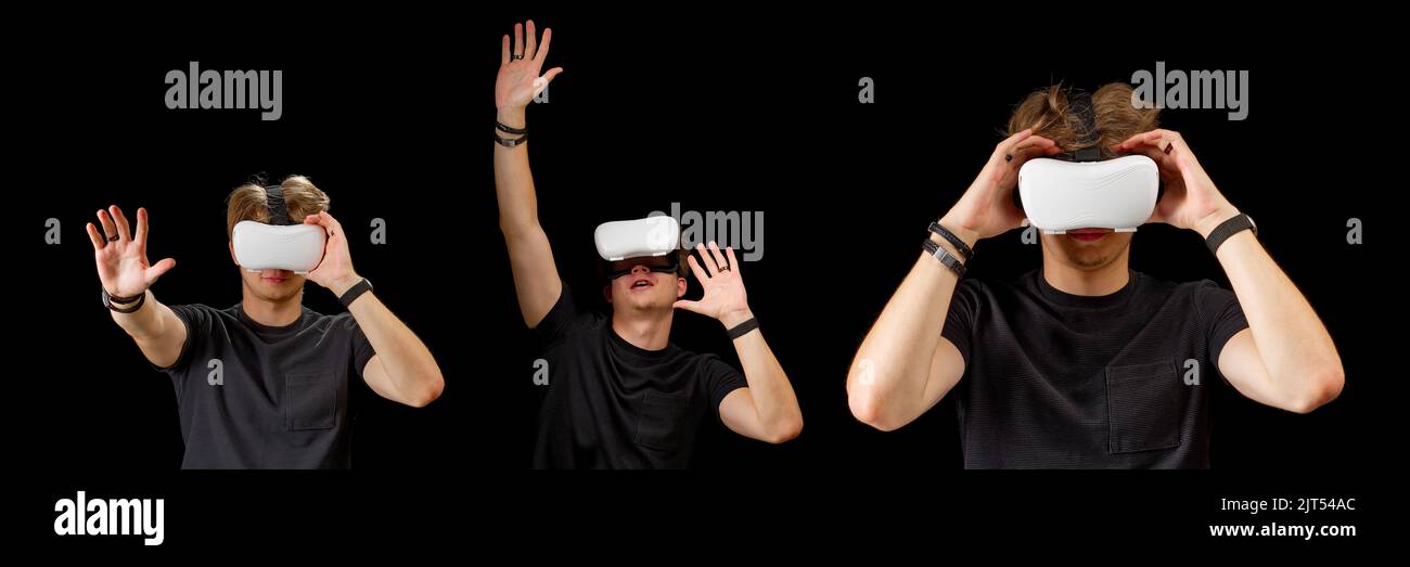 Young man wearing virtual reality VR glasses, goggles isolated on black ...