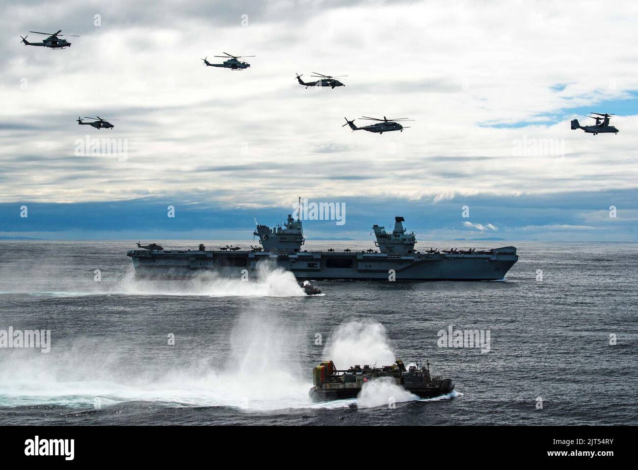 U.S. Navy aircraft fly above the Royal Navy aircraft carrier HMS Queen ...