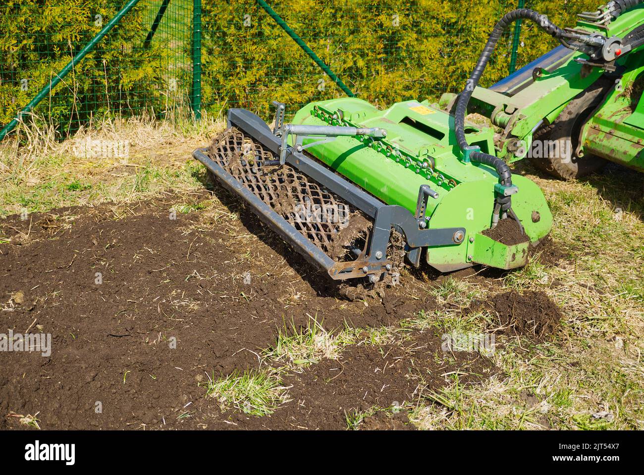The tractor is cultivating the soil in the farm field. Freeing milling ...