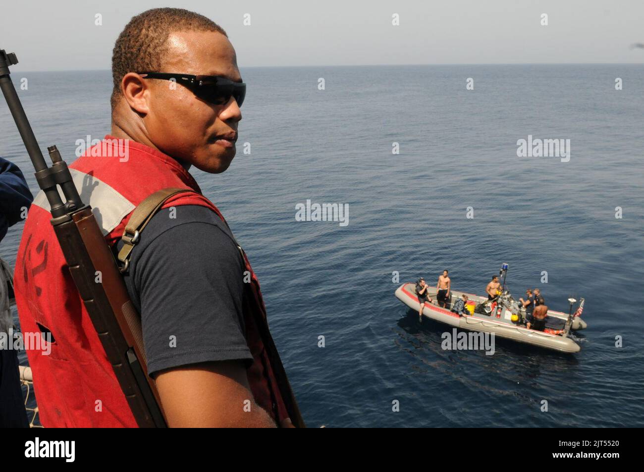 U.S. Navy Aviation Ordnanceman Airman stands watch during a swim call ...