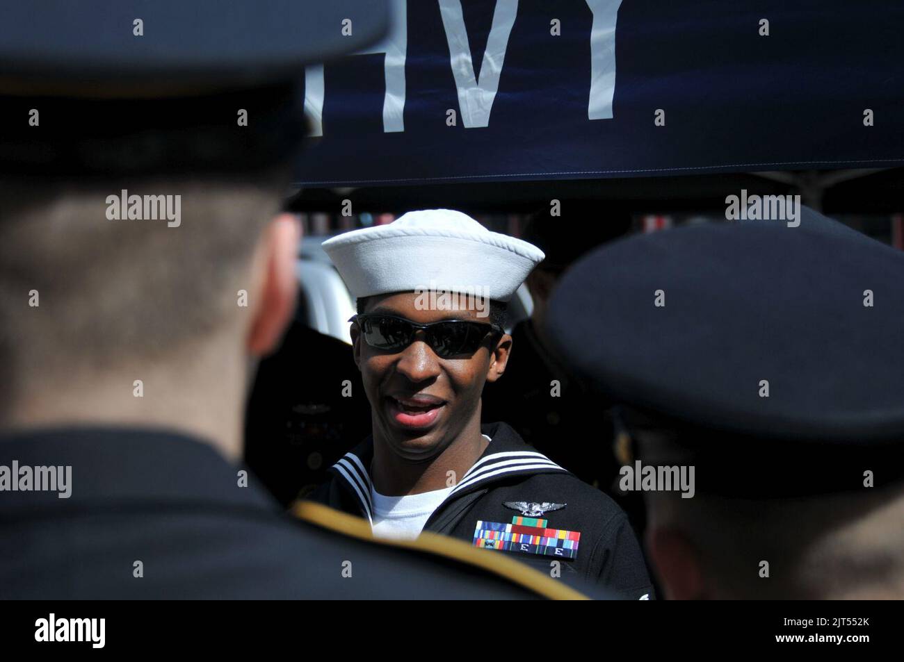 U.S. Navy Aviation Ordnanceman 2nd Class center speaks with high school ...