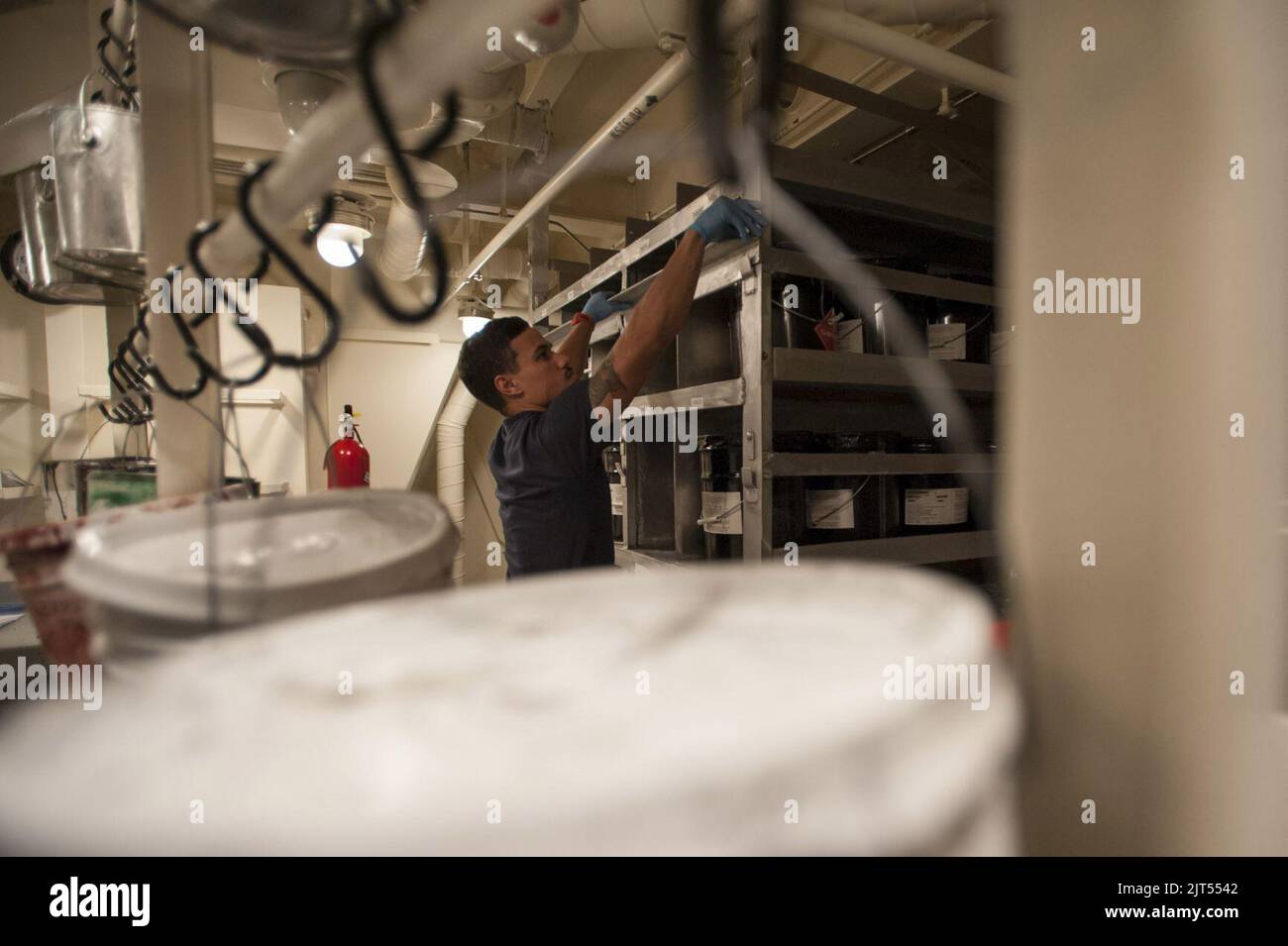 U.S. Navy Aviation Support Equipment Technician Airman secures shelving ...