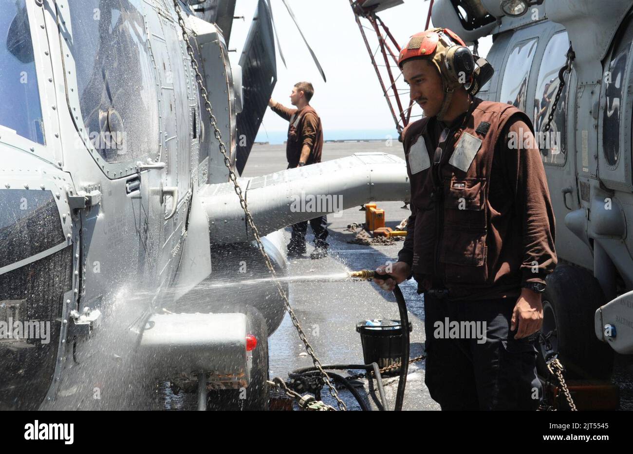 U.S. Navy Aviation Structural Mechanic Airman washes an MH-60R Seahawk ...