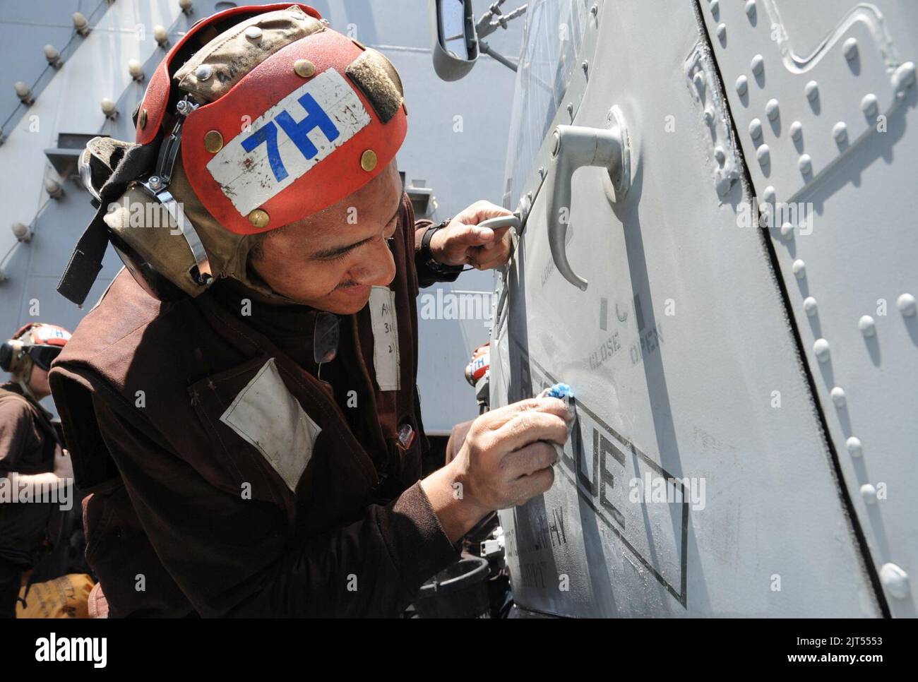 U.S. Navy Aviation Structural Mechanic Airman washes an MH-60R Seahawk ...