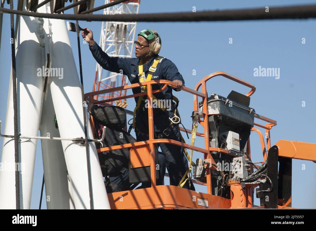 U.S. Navy Aviation Support Equipment Technician Seaman center, paints a ...