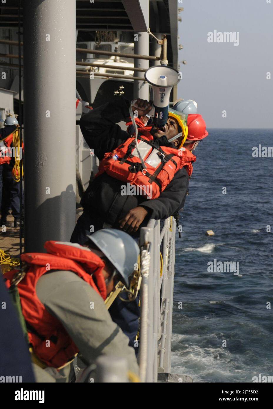 U.S. Navy Boatswain's Mate 3rd Class relays orders to the main deck ...