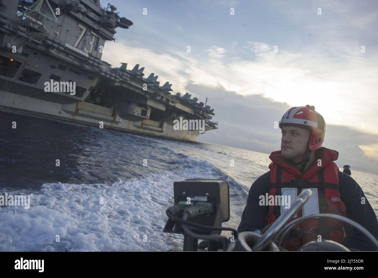 U.S. Navy Boatswain's Mate 2nd Class maneuvers a rigid-hull inflatable ...