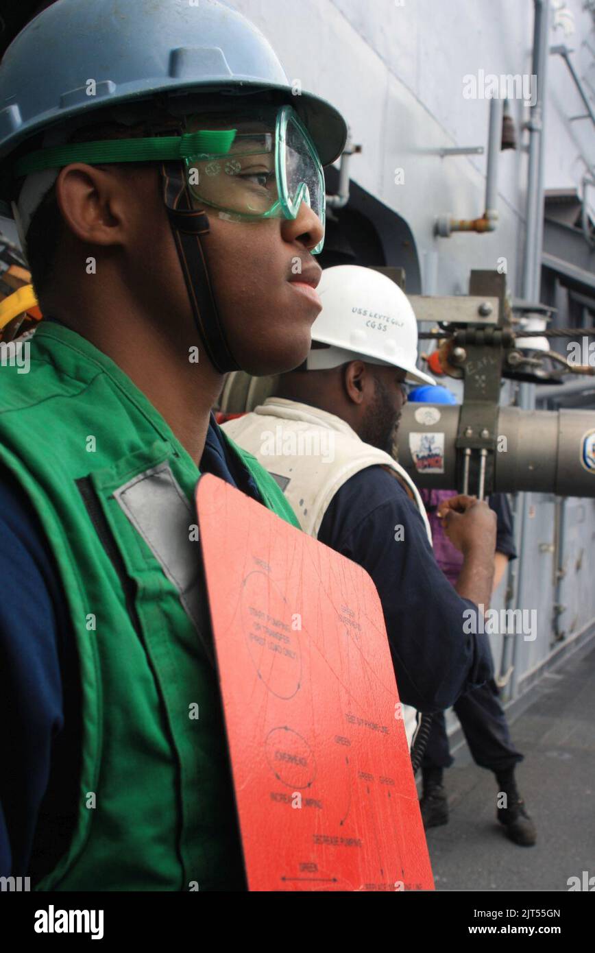 U.S. Navy Boatswain's Mate Seaman signals the fleet replenishment oiler ...