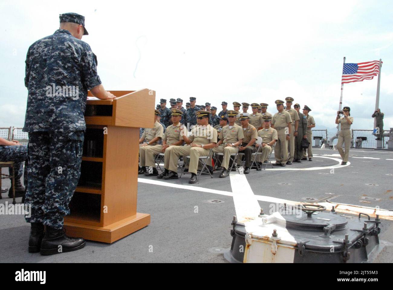 U.S. Navy Capt. at lectern, the commodore of Destroyer Squadron 7 ...