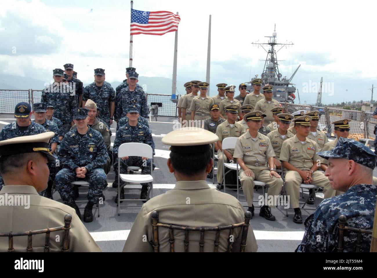 U.S. Navy Capt. right, the commodore of Destroyer Squadron 7, sits ...