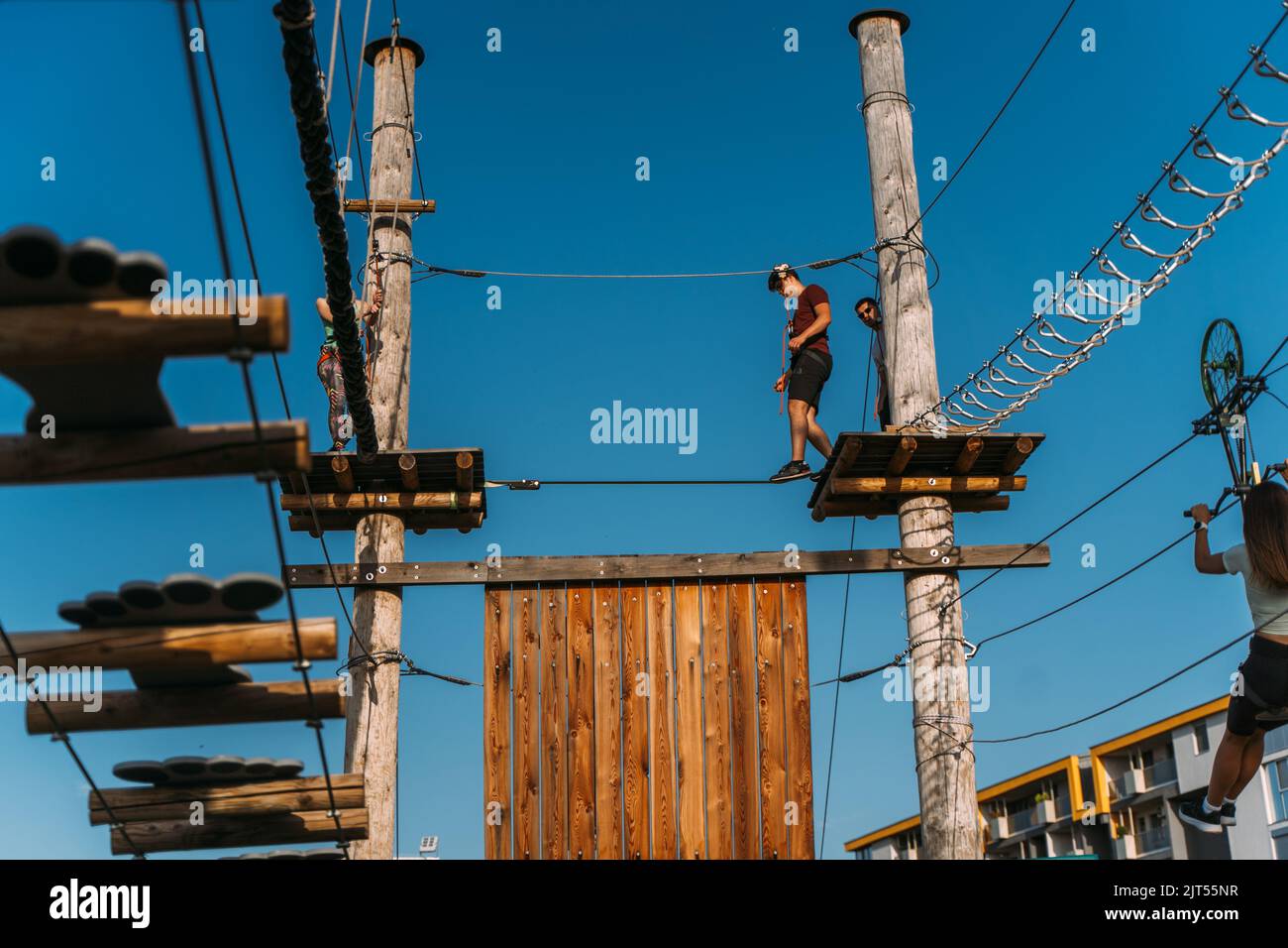 Group of climbers doing the courses in the adventure park with ease Stock Photo - Alamy