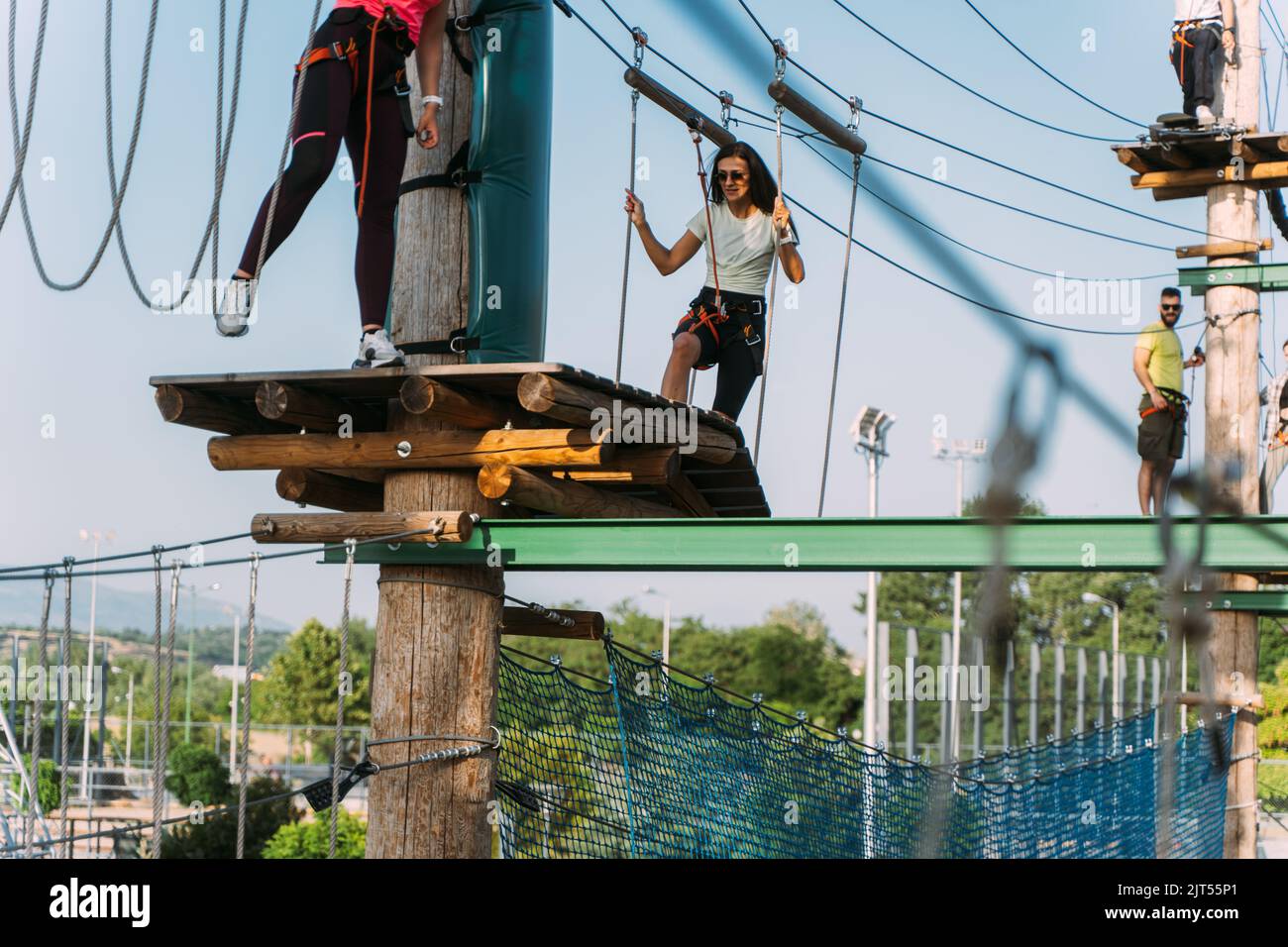 Group of climbers doing the courses in the adventure park with ease Stock Photo - Alamy