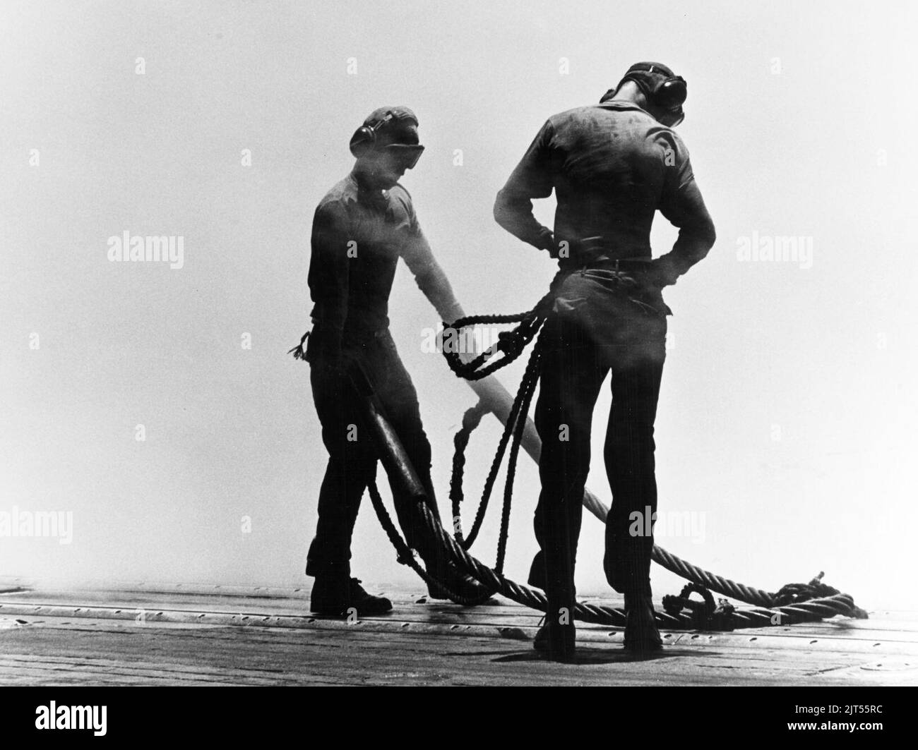 U.S. Navy catapult crewmen retrieve a launch bridle cable aboard USS ...