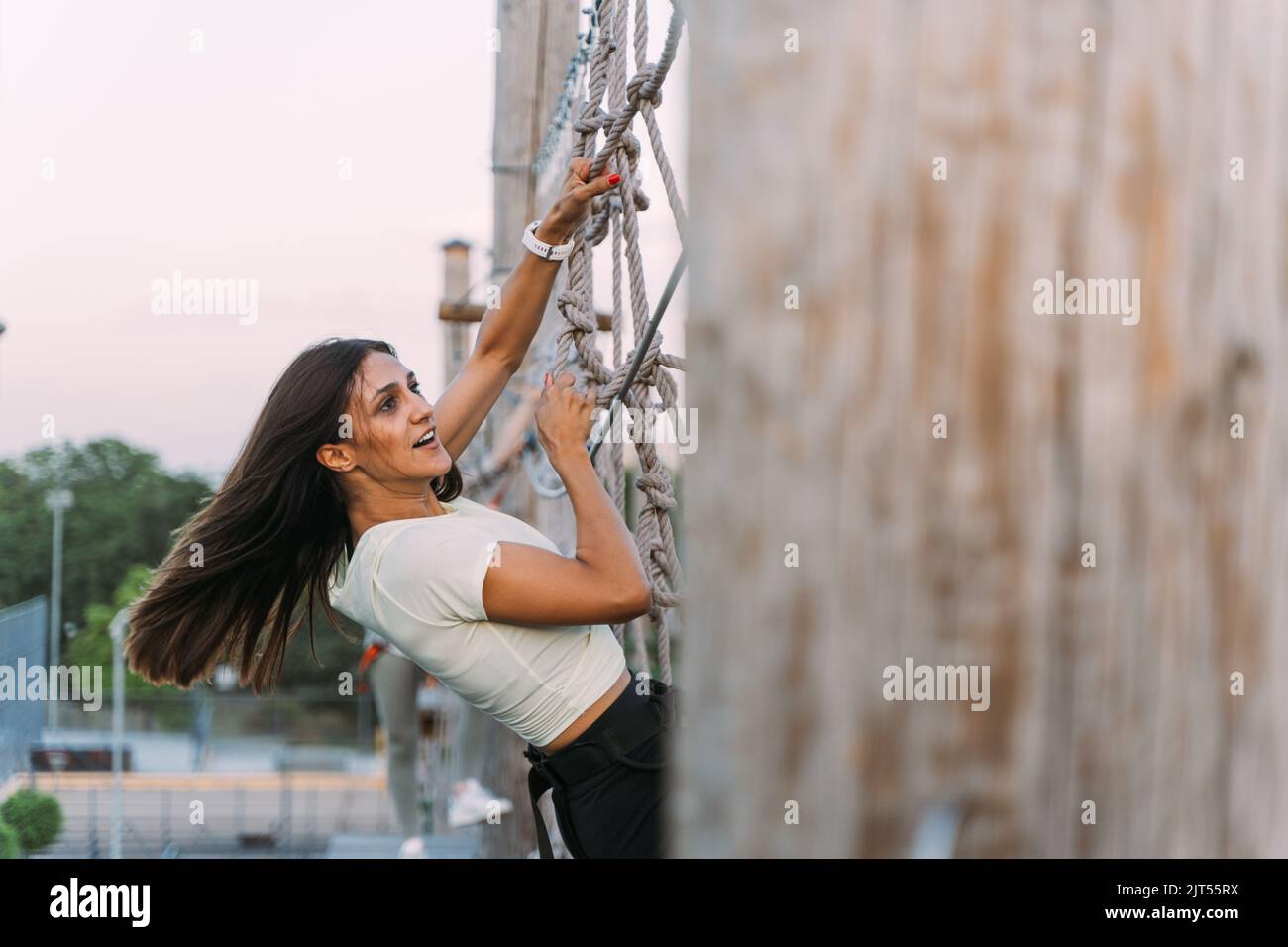 Athletic young girl going through the ropes in the adventure park Stock ...