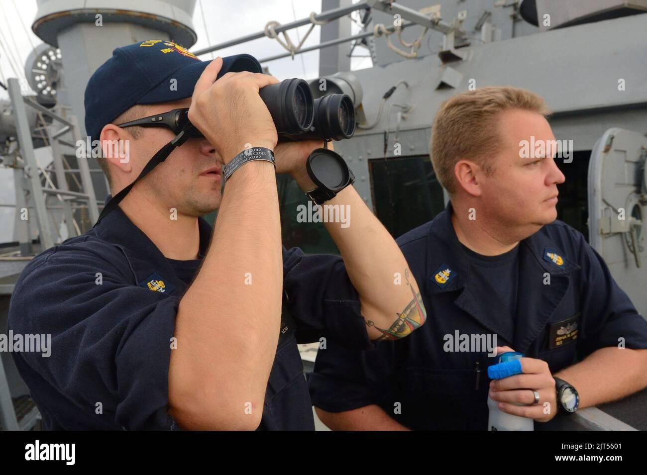 U.S. Navy Chief Master-at-Arms left, stands watch monitoring civilian ...