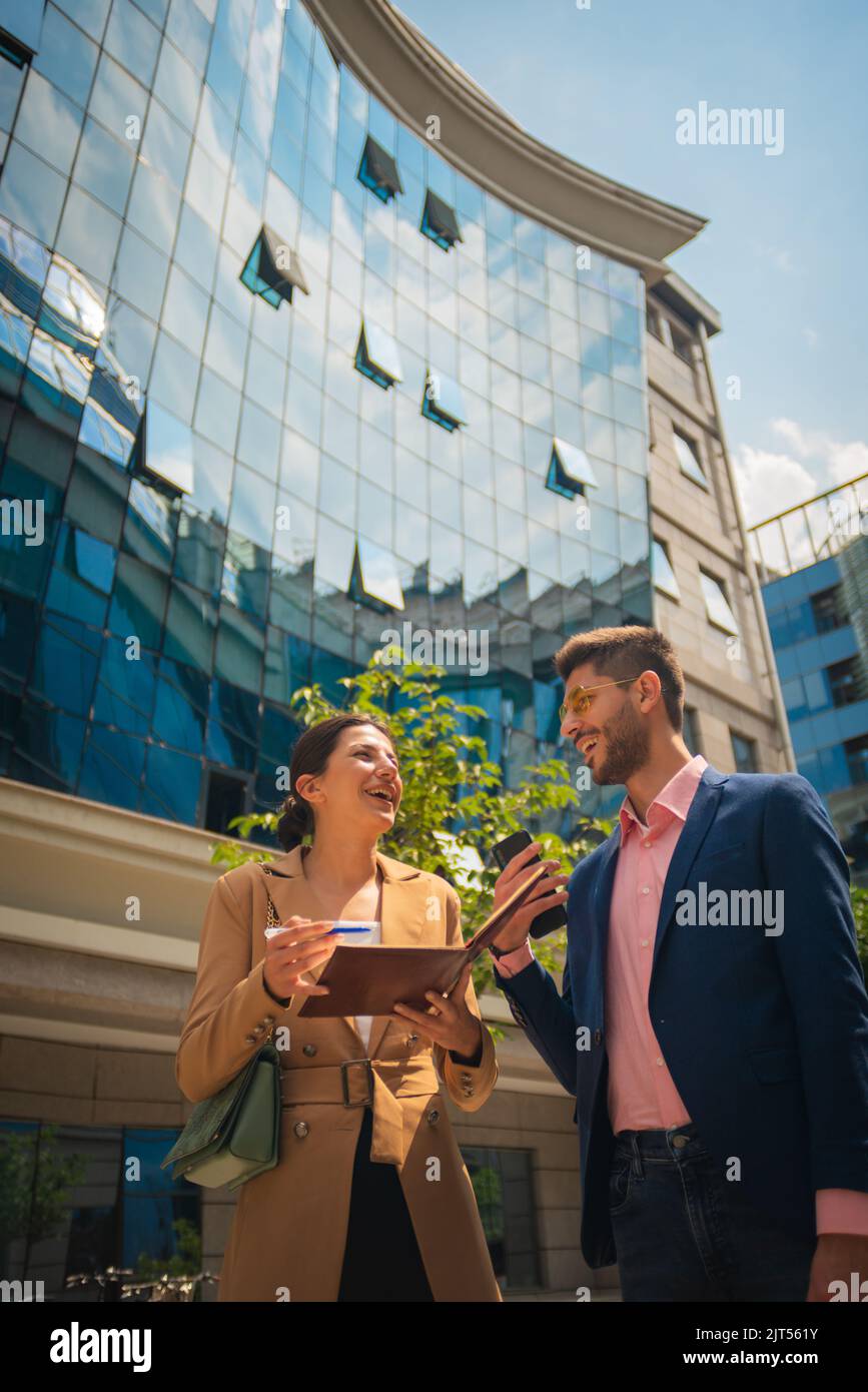 A stunning business couple just finished with their work, now are ...