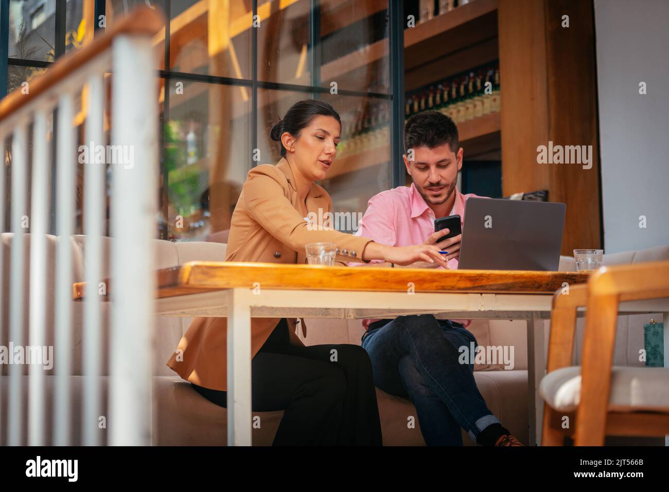 Two young businesspeople having conversation in cafe bar on a summer ...