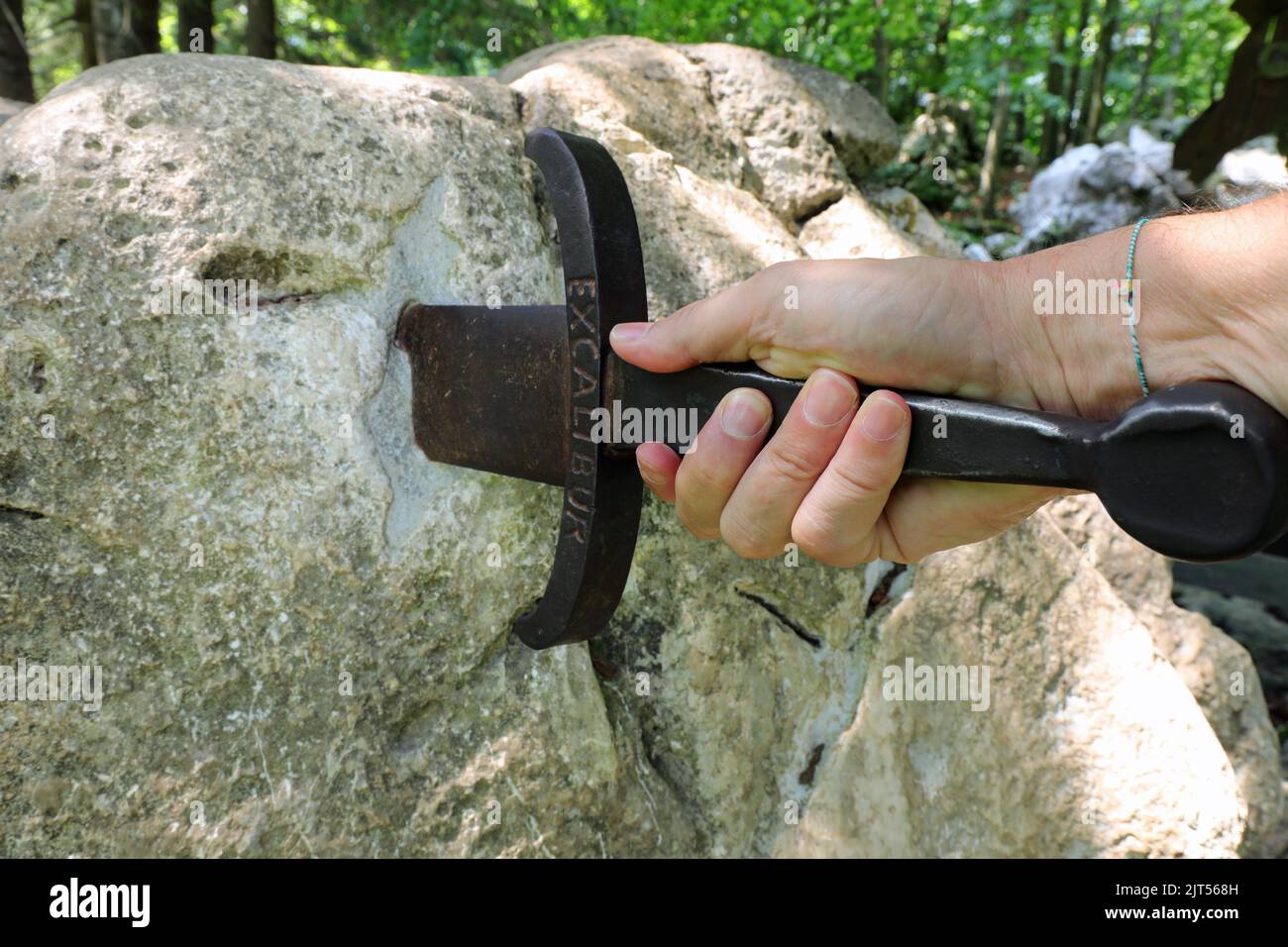 Hand grabbing the sword with the inscription Excalibur stuck on the ...