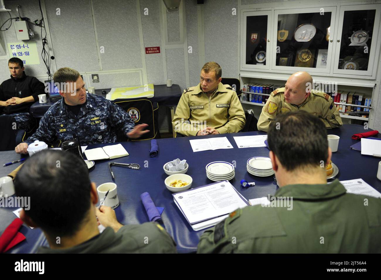 U.S. Navy Cmdr. Andrew Biehn, center left, the commanding officer of ...