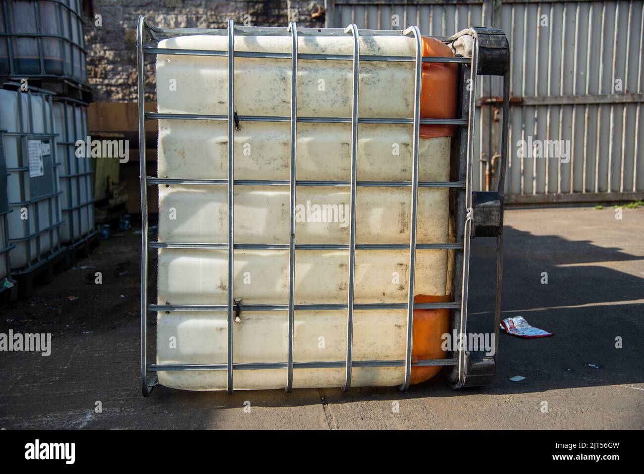Heavily used old white intermediate bulk container or IBC plastic tank ...