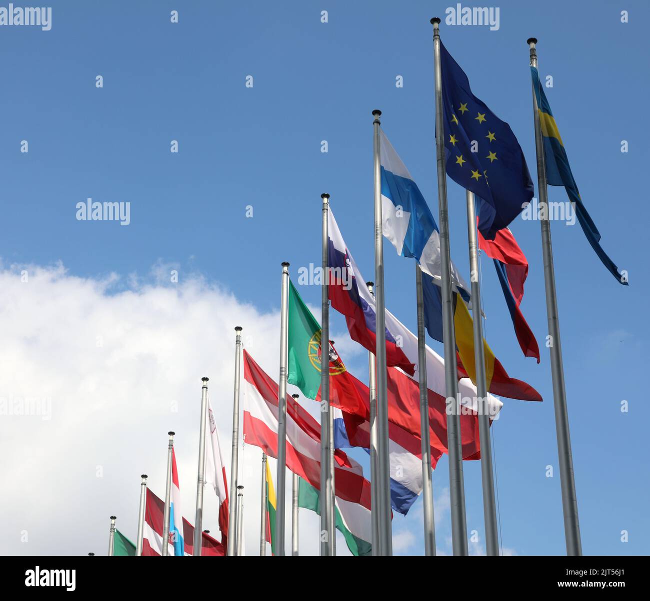 flag of Europe and other flags on the background with blue sky and ...