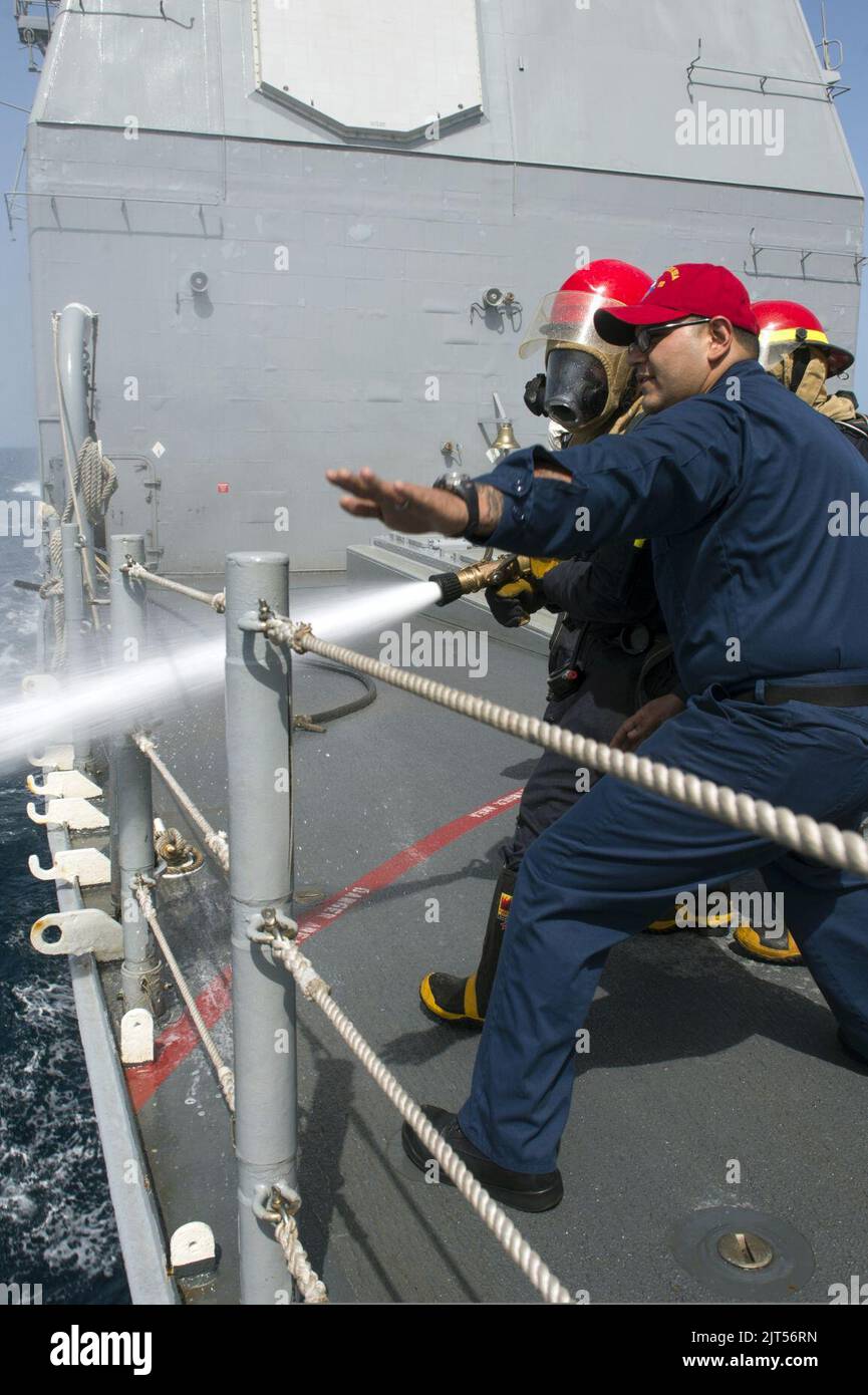 U.S. Navy Culinary Specialist 1st Class provides fire hose training ...