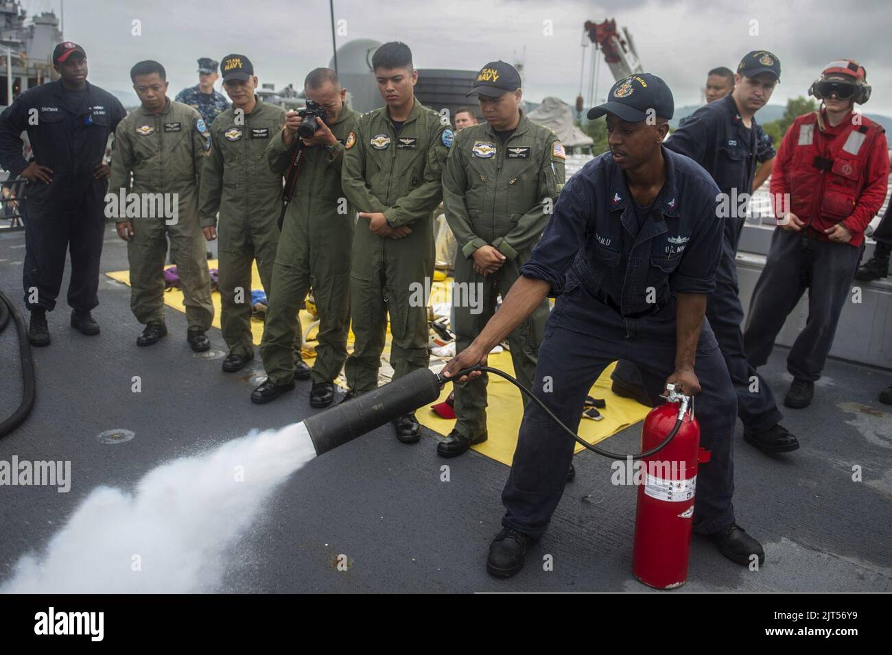 U.S. Navy Damage Controlman 2nd Class right, demonstrates firefighting ...
