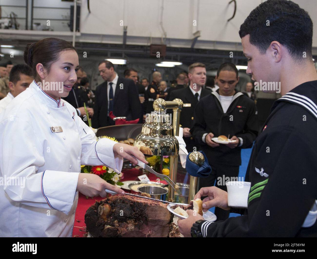U.S. Navy Culinary Specialist Seaman Recruit left, serves food during a ...