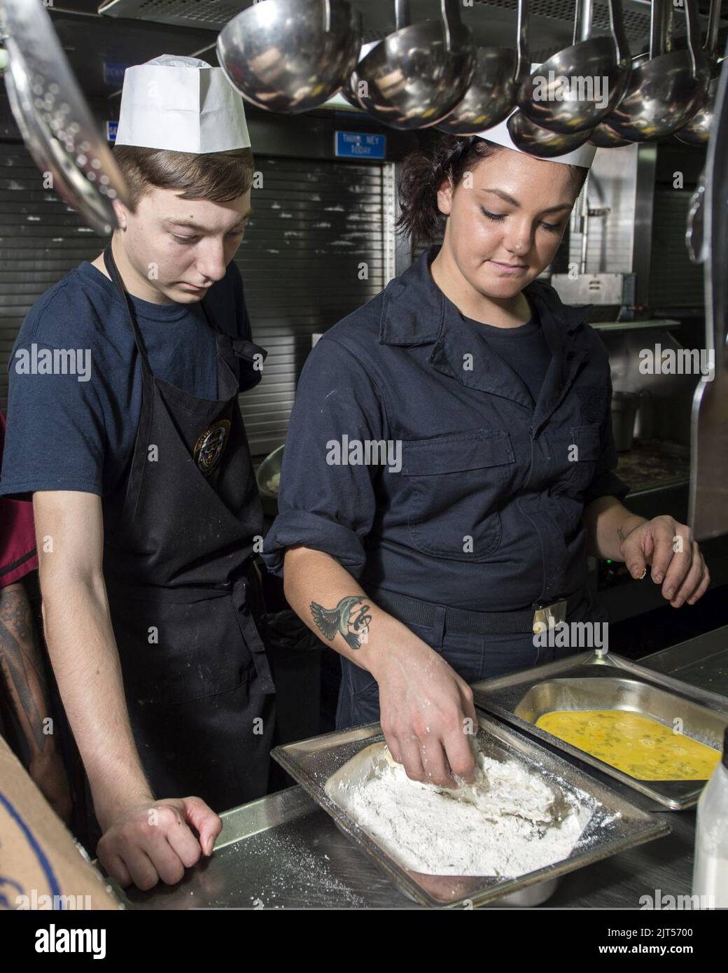 U.S. Navy Culinary Specialist Seaman left, and Seaman prepare fish ...
