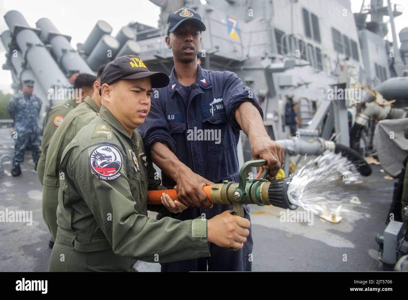 U.S. Navy Damage Controlman 2nd Class right, demonstrates firefighting ...