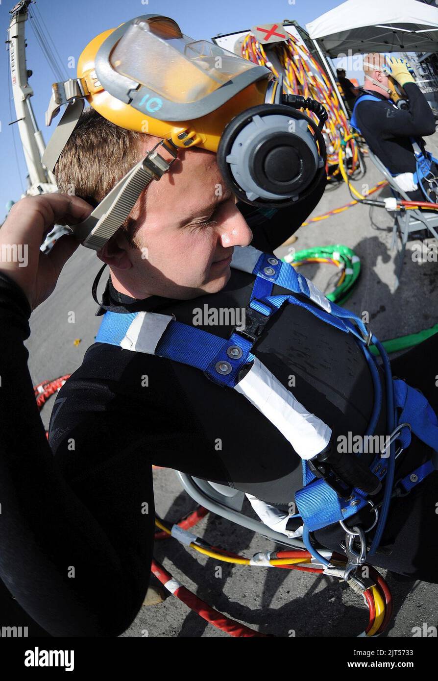 U.S. Navy Diver 1st Class dons his Mk 20 diving mask prior to a dive in ...