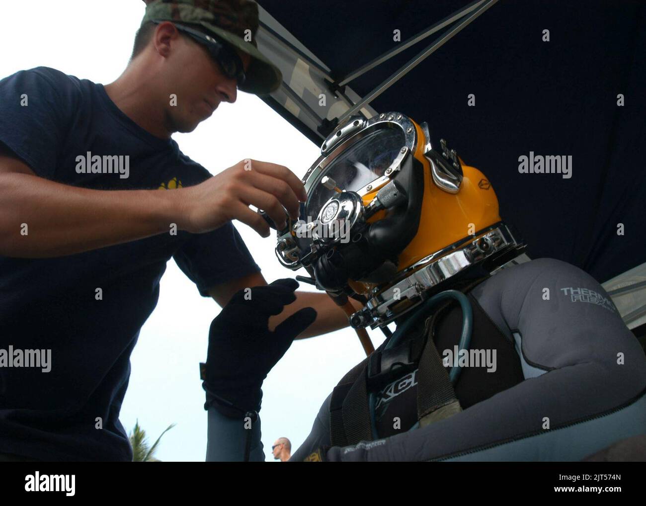 U.S. Navy Diver 2nd Class left, prepares Navy Diver 3rd Class for a ...