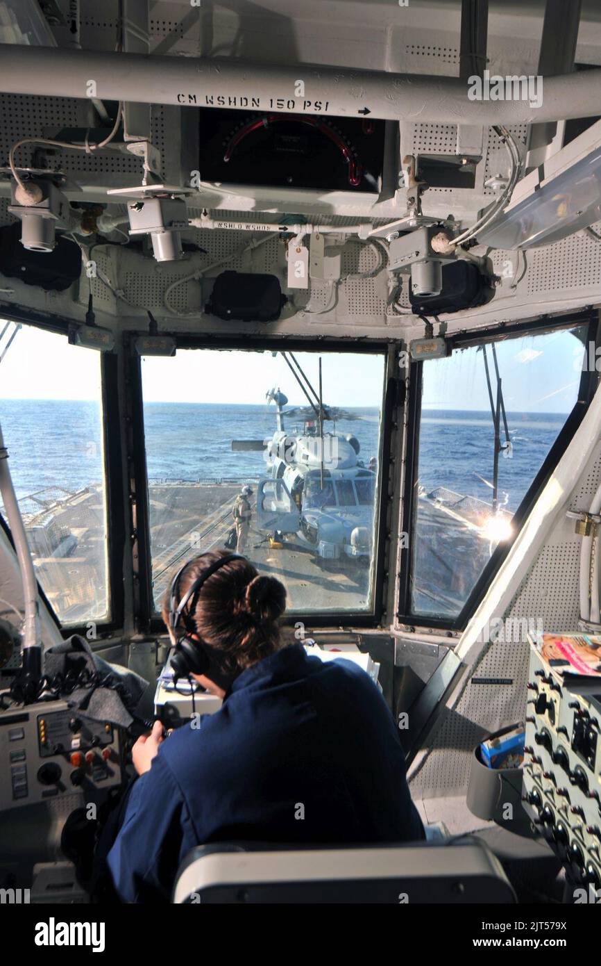 U.S. Navy Ensign communicates with the pilots of an MH-60R Seahawk ...