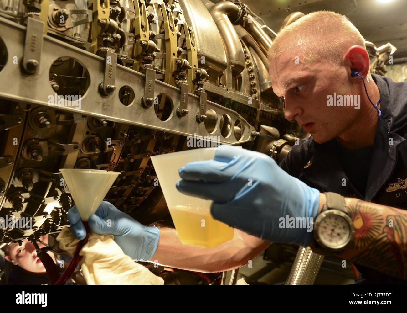 U.S. Navy Gas Turbine System Technician (Mechanical) 2nd Class pours ...