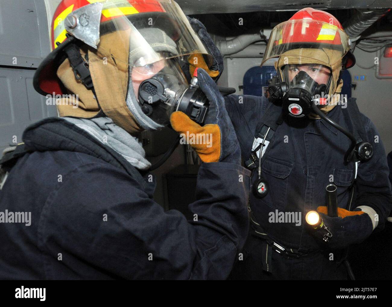 U.S. Navy fire party investigators breathe through their masks before ...