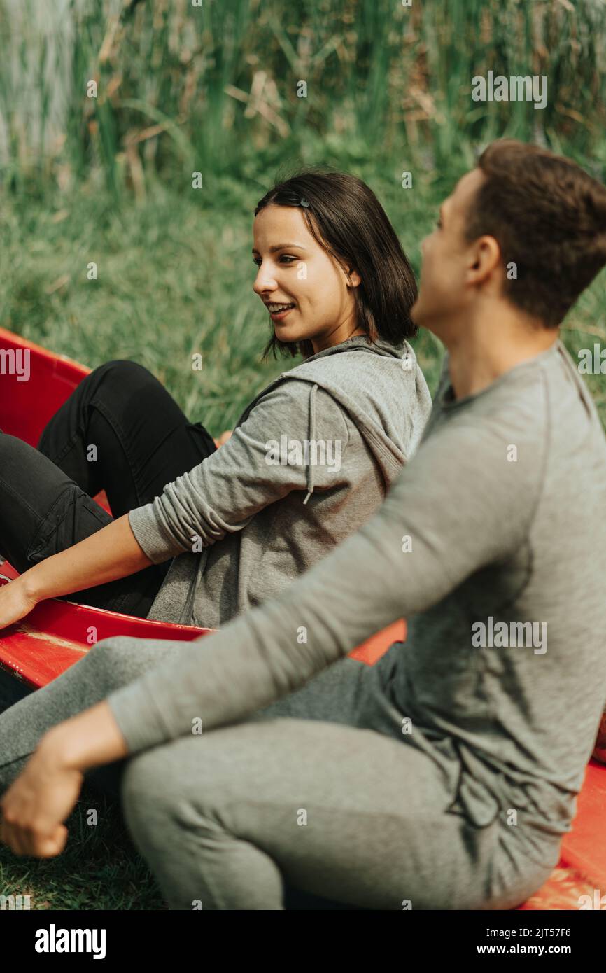 Close up of a cute couple talking while sitting on a red kayak in the ...
