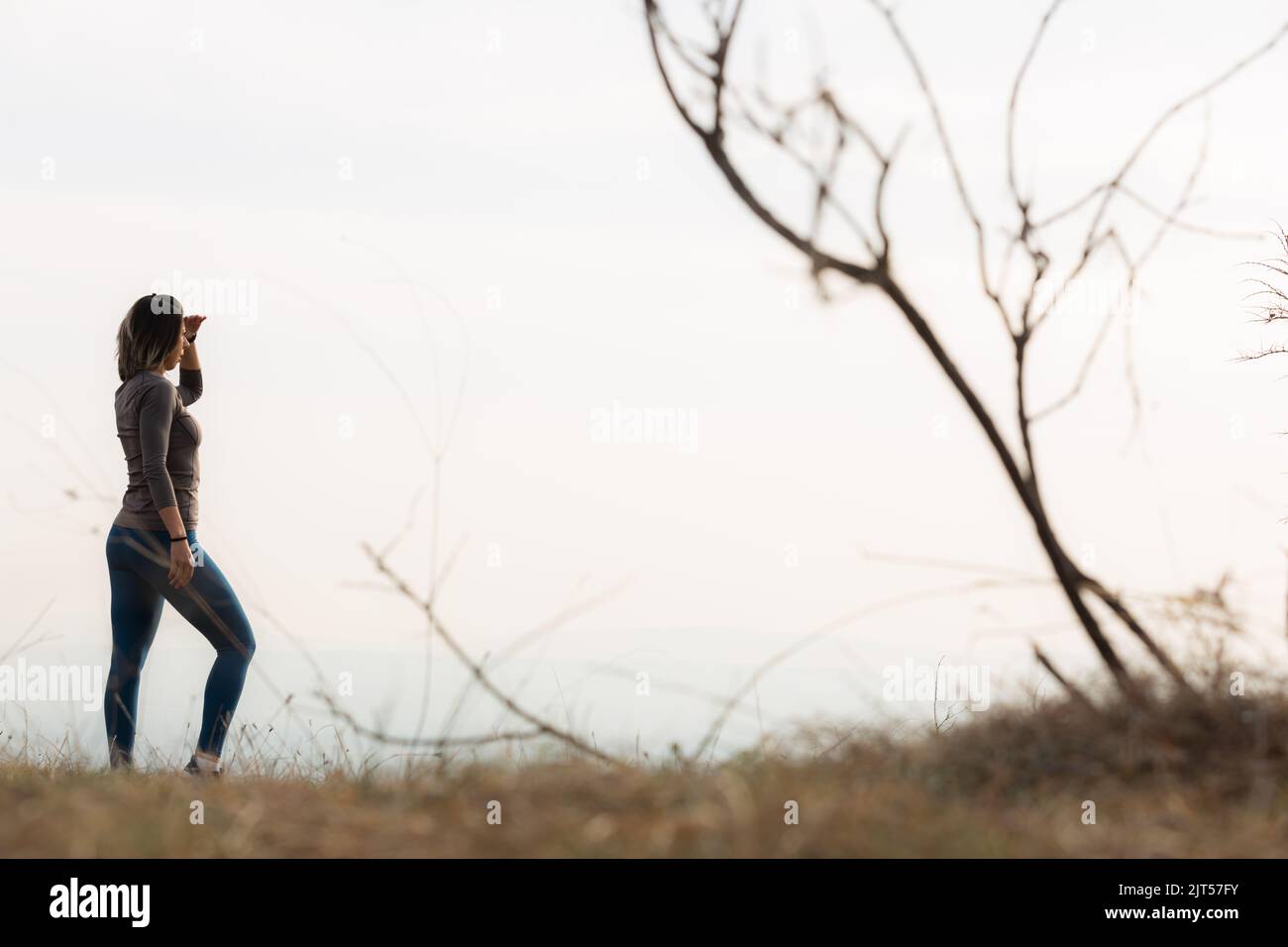 Amazing and active woman is looking at the distance and being surprised ...