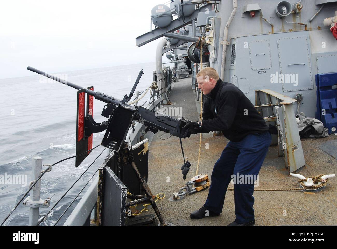 U.S. Navy Gunner's Mate inspects a .50-caliber machine gun before a ...