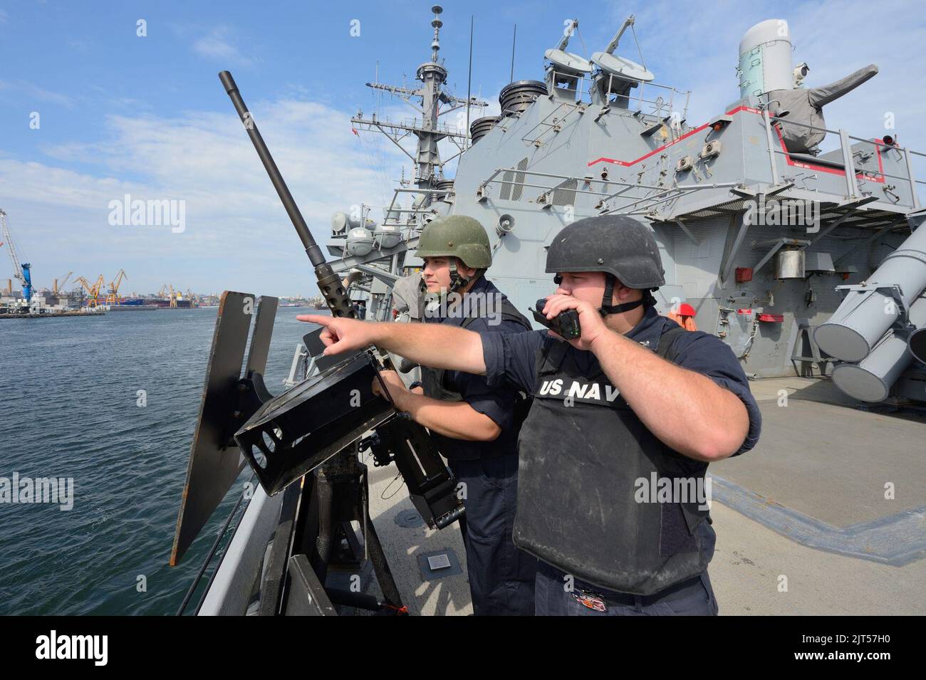U.S. Navy Gunner's Mate 3rd Class right, radios in a surface contact ...