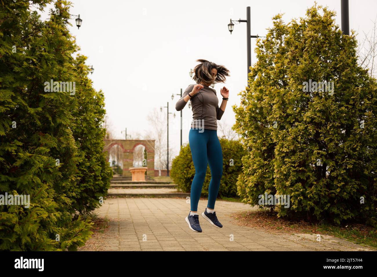 Amazing girl jumping in the park between the bushes Stock Photo - Alamy