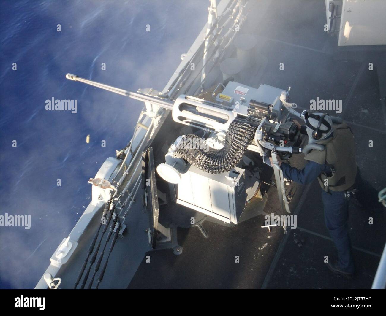 U.S. Navy Gunner's Mate 2nd Class fires a 25 mm gun March 19, 2014 ...