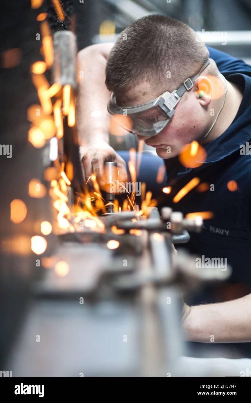 U.S. Navy Hull Maintenance Technician Fireman Apprentice repairs a ...