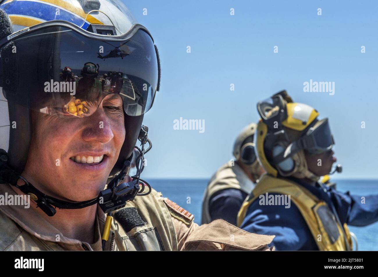 U.S. Navy Lt. Cmdr. left, participates in a vertical replenishment ...