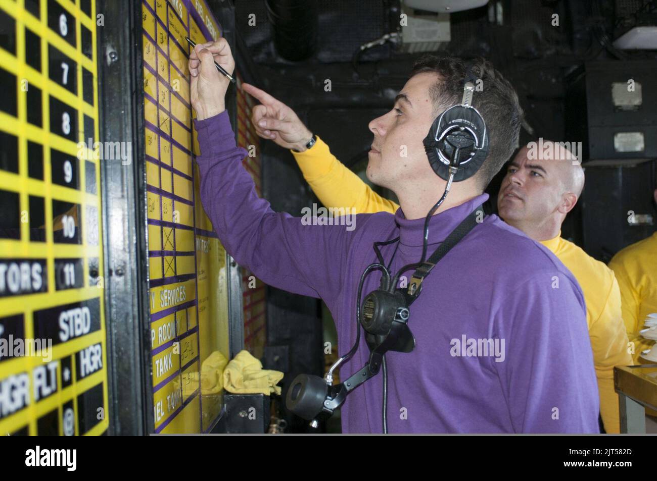 U.S. Navy Lt. a flight deck officer, reviews the fuels status board as ...